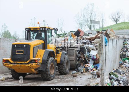 Front loader with scrap handling grapple bucket moving forward and ...