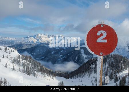 an icy red sign marks a red slope in the ski area Stock Photo - Alamy