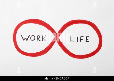 Drawn infinity sign with words Work and Life in notebook on light blue ...