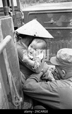 A Vietnamese mother holds her small child for a photograph, showcasing ...