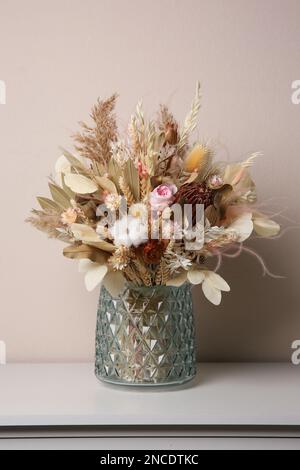Table with protea flowers near light wall in room Stock Photo - Alamy