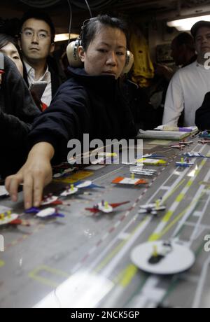 US Navy A flight deck handler guides an F-A-18 Hornet from the Mighty ...