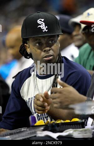 Rapper Lil Wayne sits courtside during an NBA basketball game between ...