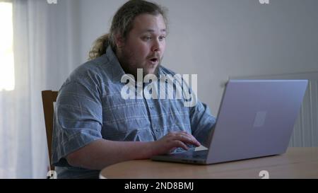 One excited chubby guy celebrating success in front of laptop computer ...