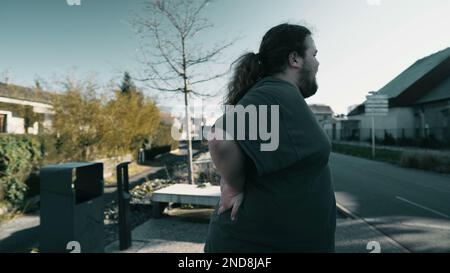 Dramatic moment of person suffering from back pain. An overweight man ...