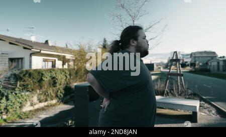 Dramatic moment of person suffering from back pain. An overweight man ...