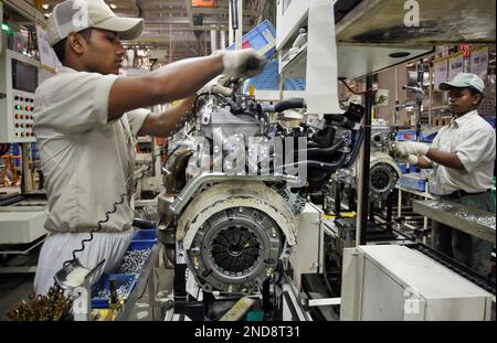 A worker finishes an engine at the Maruti Suzuki assembly line of the K ...