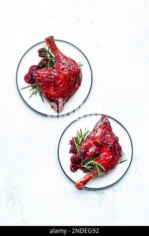 Baked duck legs with cherry red wine sauce with fresh rosemary in old ...