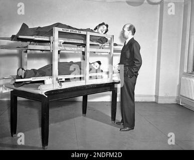 The two-stretcher cradle is use, William V. C. Ruxton, designer, poses ...