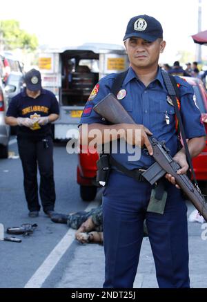 A policeman secures the crime scene as the body of a Philippine Marine ...
