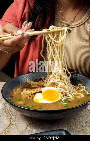 Lifting Noodles with Chopsticks from a Bowl of Chinese Braised Beef ...