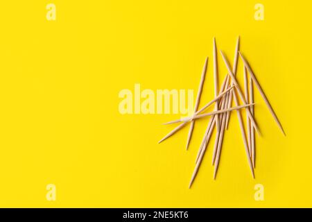 Wooden toothpicks on yellow background Stock Photo - Alamy