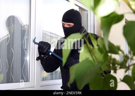 masked burglar with crowbar on a window Stock Photo - Alamy