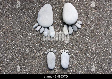 large and small stone feet on asphalt Stock Photo - Alamy