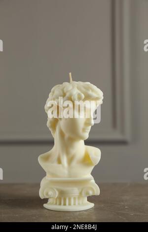 Beautiful David bust candle on grey table. Space for text Stock Photo ...