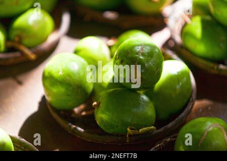 Close-up on a bowl of ambarellas (jew plums) for sale on a market stall ...