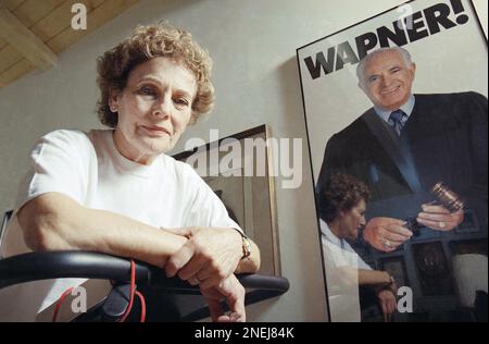 Mickey Wapner poses on her tredmill near a photograph of her husband at ...