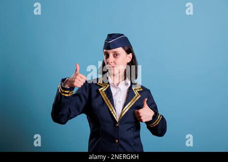Smiling flight attendant showing thumbs up gesture, aviation academy ...