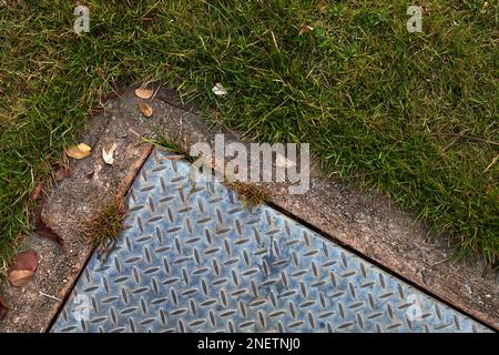 Steel pavement to the edge of the cement and lawn Stock Photo - Alamy