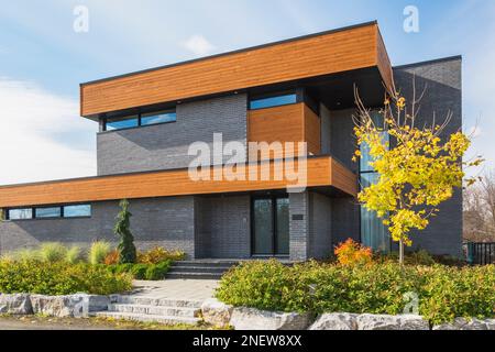 Modern grey brick and stained wood finish cube style house facade with ...