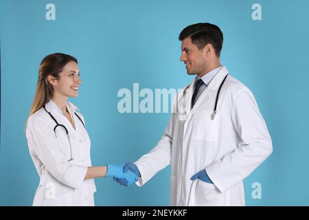 Doctors shaking hands on light grey background, closeup Stock Photo - Alamy