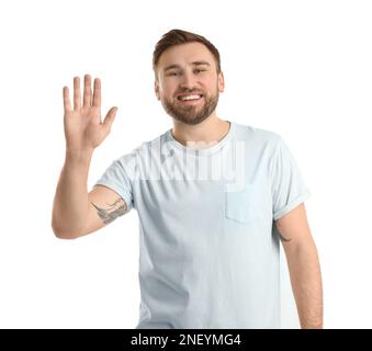 Happy young man waving to say hello on white background Stock Photo - Alamy