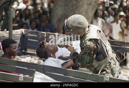 An American soldier gives a drink of water to member of the 1st ...