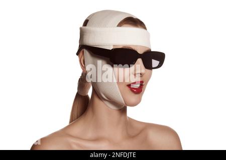 Female face bandaged with medical bandages and sunglasses with human ...