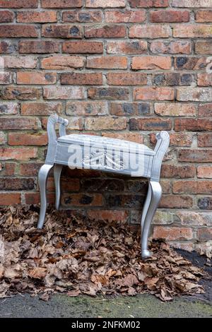 Abandoned silver stool against a red brick wall Stock Photo - Alamy