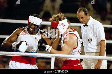 Henry Tillman takes a right to the head as he scores with a left to ...