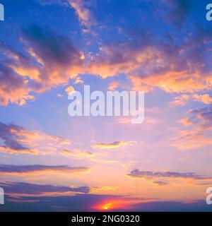 Fantastic pink sunset against bright blue sky with fluffy white clouds ...