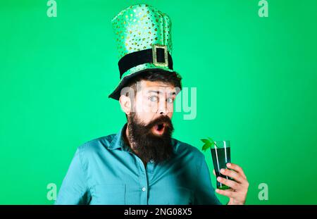 Bearded and green. Hipster in leprechaun hat and costume keeping arms ...