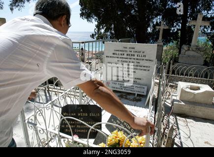A rugby fan looks at William Webb Ellis' grave at the cemetery of ...