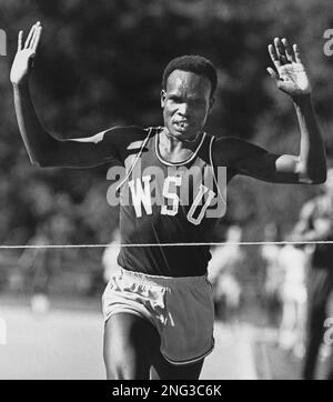 Kenyan distance runner Henry Rono, right, takes a victory lap with ...