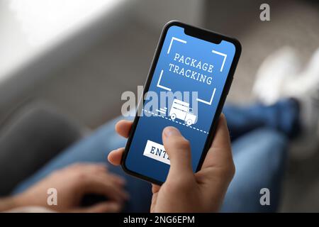 Man tracking parcel via smartphone on white background, closeup Stock ...