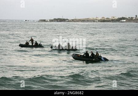 Italian Marines Commandos survey the beach on a dinghy in preparation ...