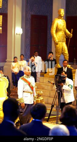 Cambodia's King Norodom Sihamoni stands up, bathed in holy water and ...