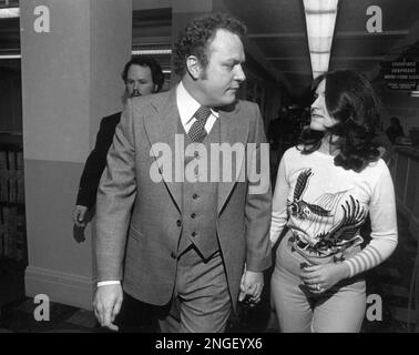 Hustler magazine publisher Larry Flynt drapes his leg over the arm of a ...