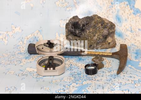Geological fieldwork tools: hammer, compass, magnifying glass, rock ...