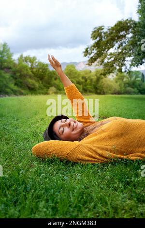 Beautiful happy young woman lying on the floor holding a Christmas ...