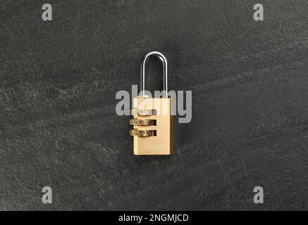 Modern combination lock on black background, top view. Space for text ...