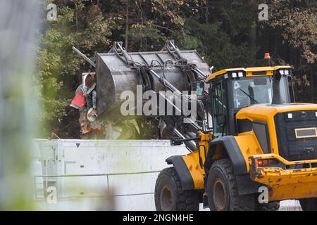 Waste loading operation, loader dumping trash in a truck on a site for ...