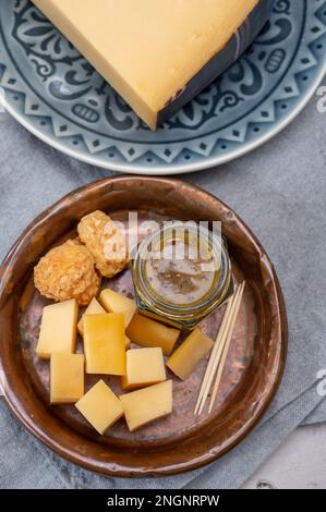 Cheese tasting, small pieces of old Dutch hard cheese and bowl with ...