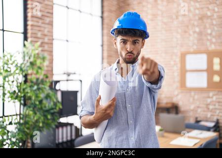 Arab man with beard wearing architect hardhat at construction office ...
