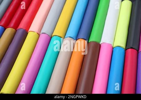Many different colorful plasticine pieces and sculpting tools on white ...