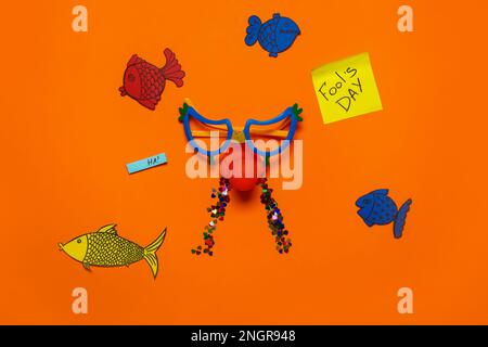 Composition with party decor and paper fishes on color background ...