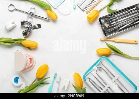 Frame made of dentist's tools and tulips on white background. Hello ...