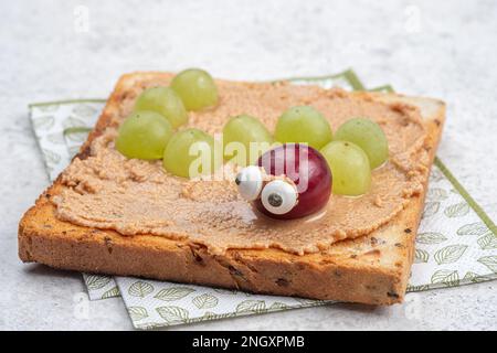 Funny worm sandwich with peanut butter and grapes Stock Photo - Alamy