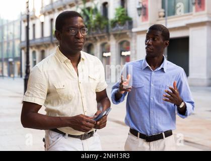 Conversation of two african americans on the street of european city on ...