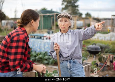 Two angry casual women neighbors of different ages arguing during the ...